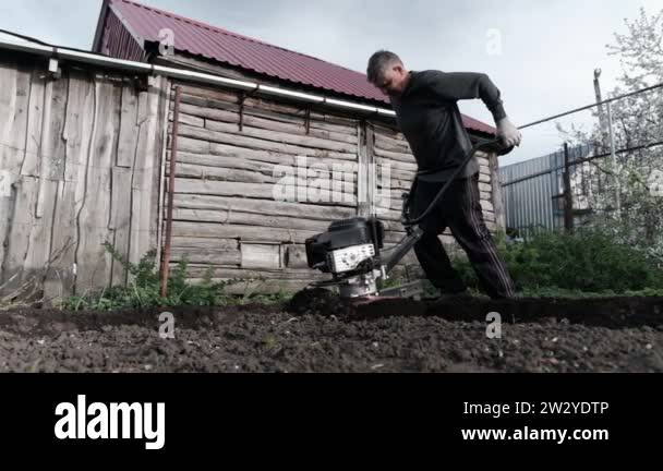 old man plowman plows the earth with a big effort motoblock. Very hard work. 4k Stock Video ...