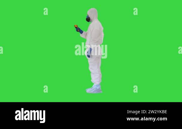 Doctor wearing protective clothes using infrared forehead thermometer ...
