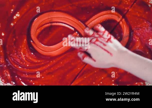 bloody hand writes a sign of infinity on the bloody spot on the floor ...