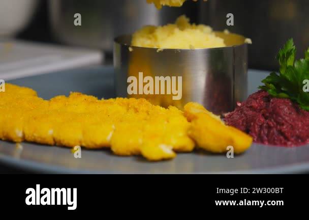 Close up male hand of cook putting mashed potatoes with the spoon into ...