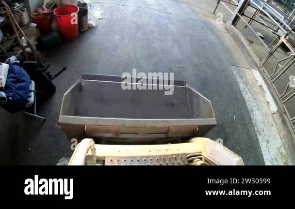 4K, Dairy farmer driving tractor in modern stable. Peasant work with ...