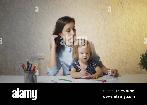 Young female babysitter mom teaching happy cute kid daughter drawing ...