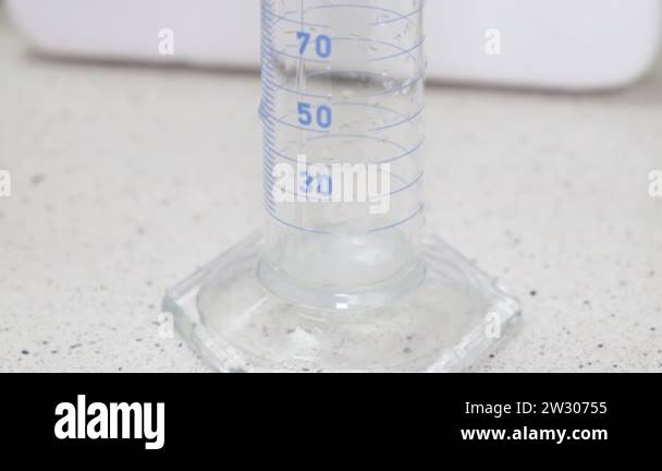 Filling of measuring cylinder. Cylindrical lab glassware showing ...