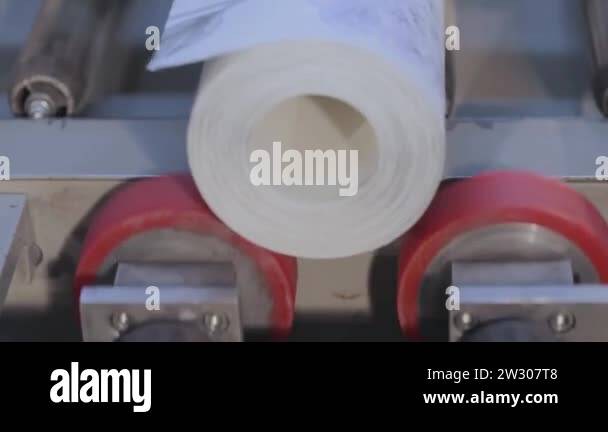 Roll of wallpaper. Conveyor line at wallpaper factory. A roll of ...
