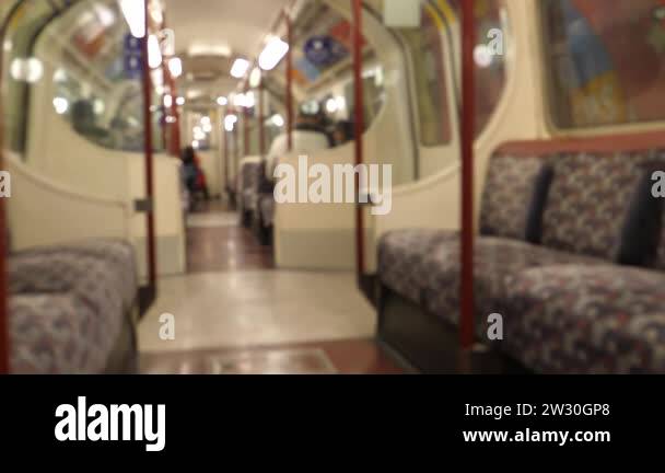 Blurred view of inside of tube carriage with people. Train is stopping ...