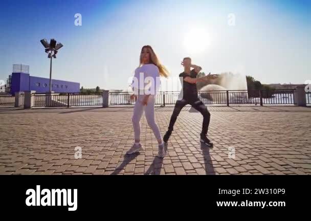 Young dancers moving in tact. Boy and girl dancing together outdoors ...