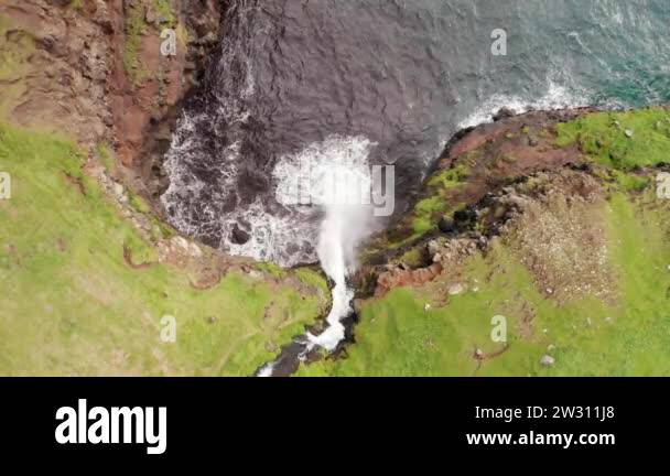 Stunning waterfall splashing from cliff aerial view. Mulafossur ...