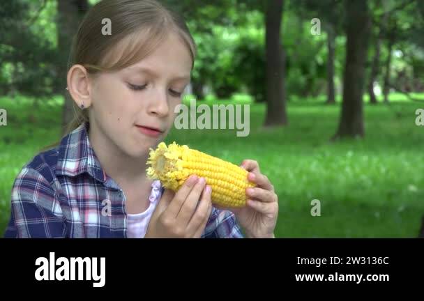 Kid Eating Boiled Corn Outdoor in Park, Hungry Girl Eats Healthy Snack ...