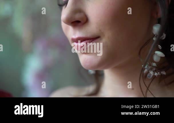 the girl s lips bite and eat a red apple. The woman s face is close-up ...