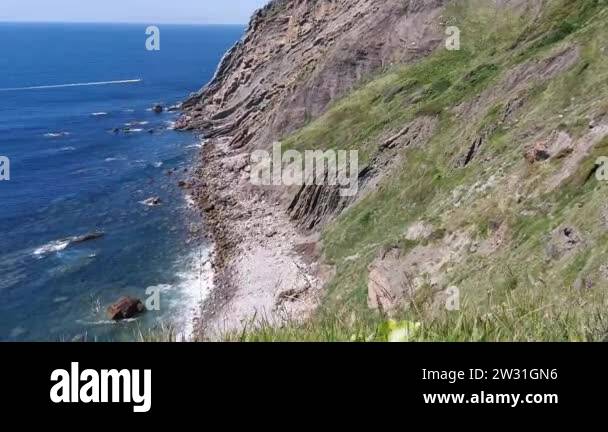Cliff with vegetation and a cove without access in the Cantabrian ocean ...