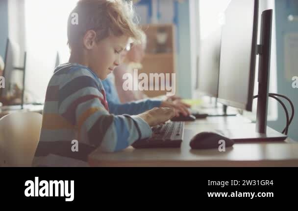 Elementary School Classroom: Smart Boy Uses Personal Computer, Learning ...