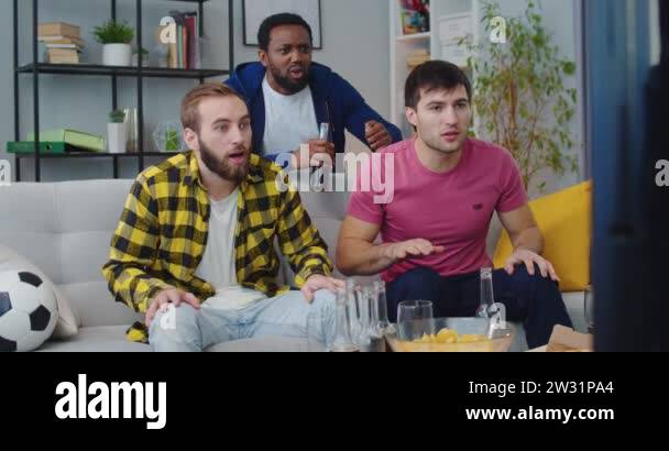 Excited cheerful mixed-races male friends football fans watching soccer ...