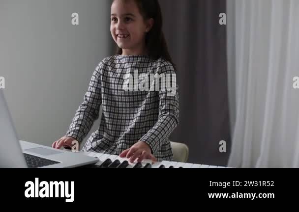 little girl watching music lesson online and studying from home. little ...