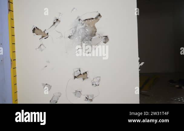 Wall made of gypsum cardboard being destroyed. Worker in uniform ...