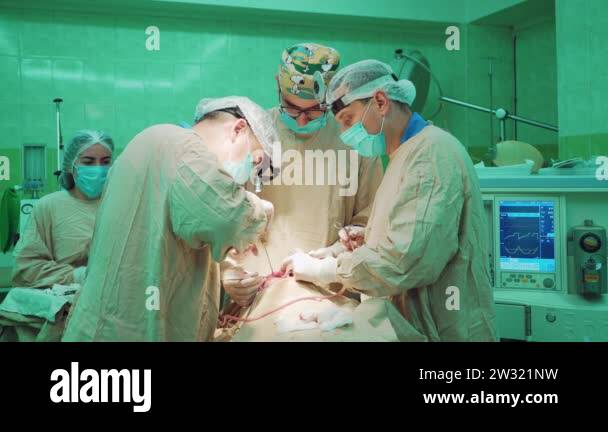 Three professional surgeons men and assistant woman are making an ...