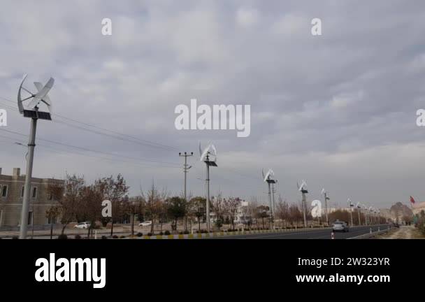 Traffic by highway with solar panel and windmill power generators on ...