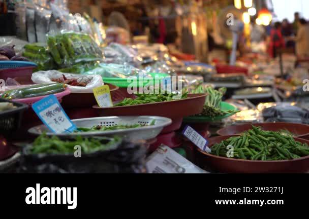 4K A traditional hawker selling green chilli peppers and other ...