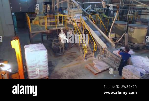 Loading bags onto a conveyor belt. Vacuum manipulator lifting bags on a ...