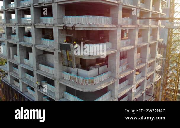 Workers are Installing the Precast Glass Panel on The Construction Site ...