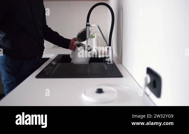 Video process of guy turning on faucet and pouring water in it. Then ...