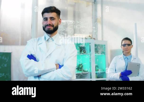 Biotechnology laboratory two young scientists in the uniform posing ...