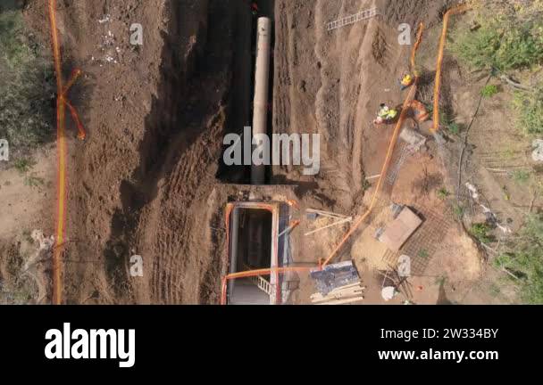 Top down aerial above construction site with workers and excavator ...
