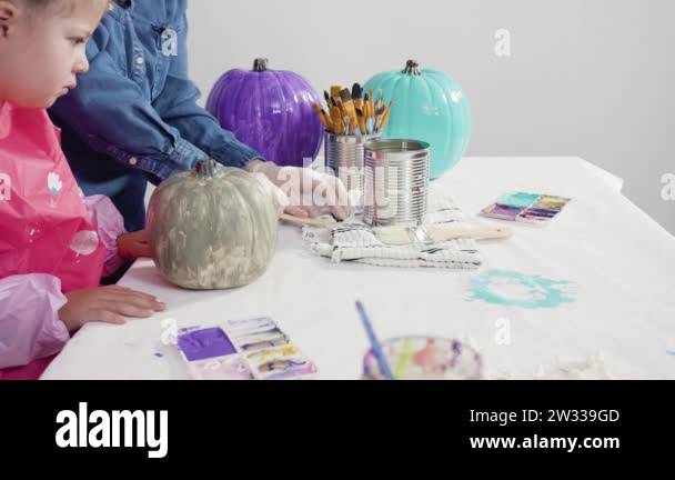 Little girl painting paper mache figurines with acrylic paint for her ...