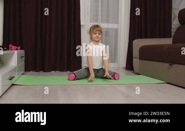 Child kid girl doing gymnastics fitness stretching workout at home ...