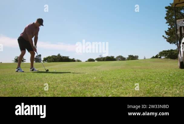 Rear view of a Caucasian male golfer standing on a golf course on a ...