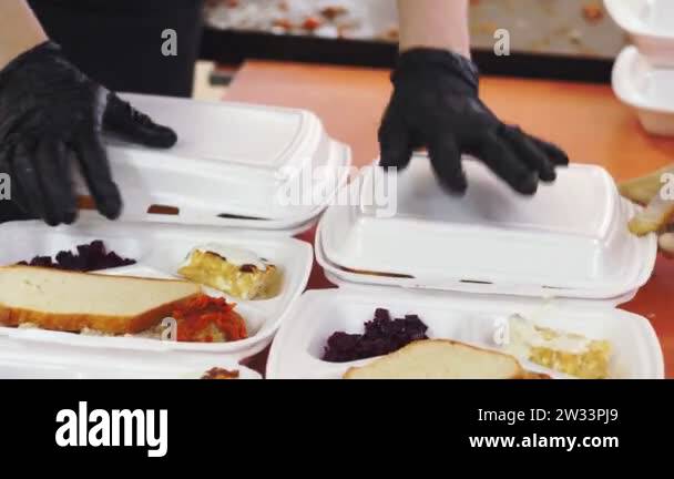 close-up, Volunteers pack free hot meals in lunchboxes, to be delivered ...