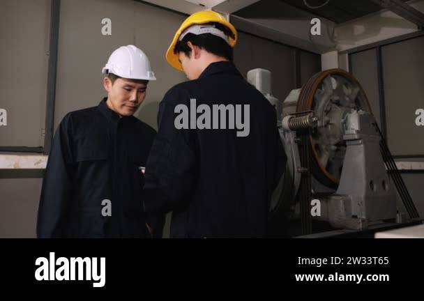 Two mechanical engineer talking to solve problems of the motor system ...