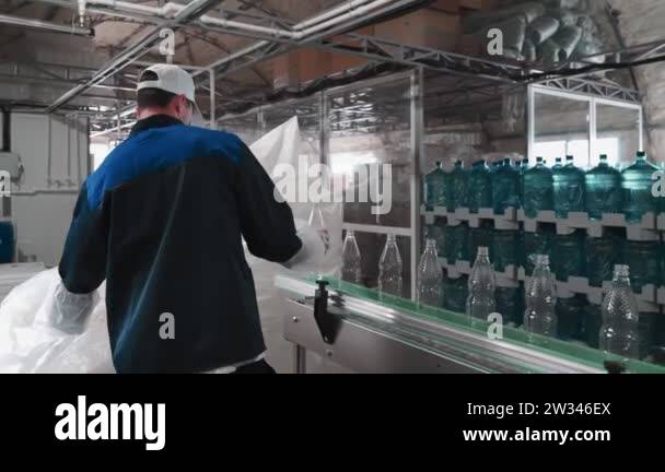 Pure drinking water plant. Work conveyor in the enterprise. Factory ...