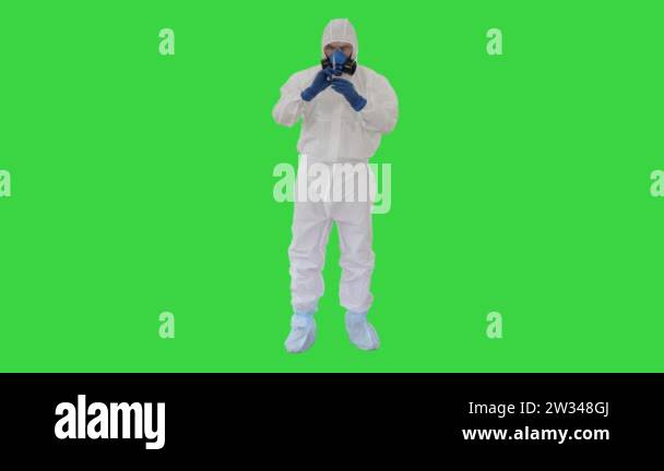 Doctor in hazmat protective with glasses and respirator uses syringe on ...