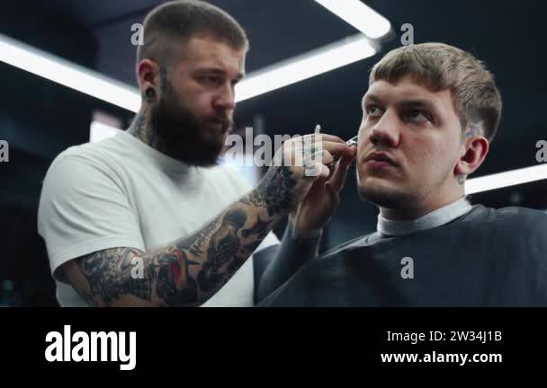 Barber cuts the hair of the client with scissors. Close up. Attractive ...