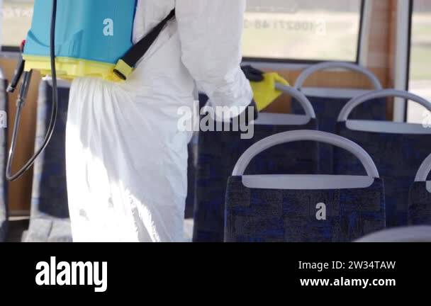 Hazmat team worker disinfects bus interior with antibacterial sanitizer ...