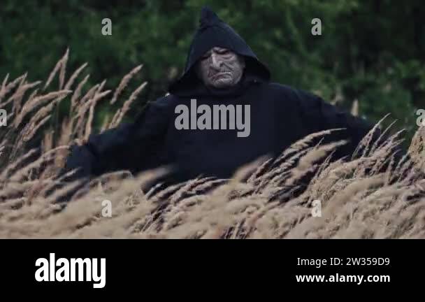 Spooky evil with horrorful face outdoors. Scary view of a black ghost ...