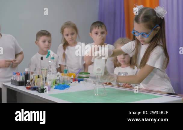 Chemical experiments for children. Girl pours ingredients into a ...