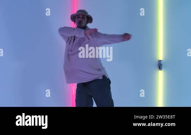 Young handsome guy with tattoos is dancing hip hop against background ...