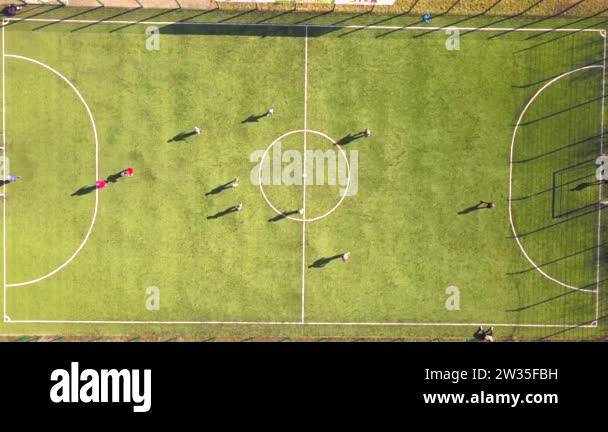 Top down aerial view of green football sports field and players playing ...