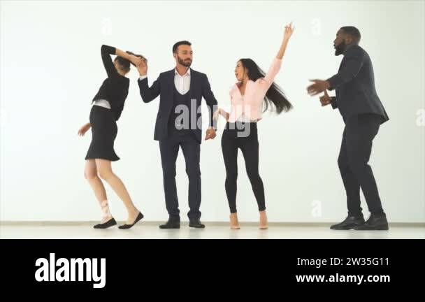 The four happy people dancing on the white background. slow motion ...