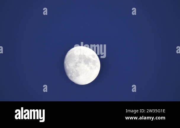 The full moon in sky moves across the horizon. Close-up moon, craters ...