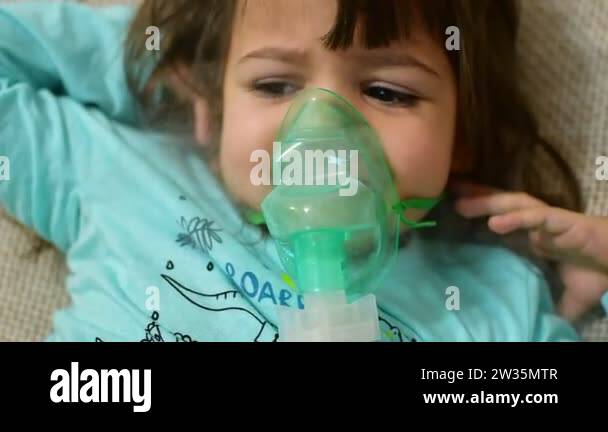 Little kid girl making inhalation with nebulizer at home. Child asthma ...