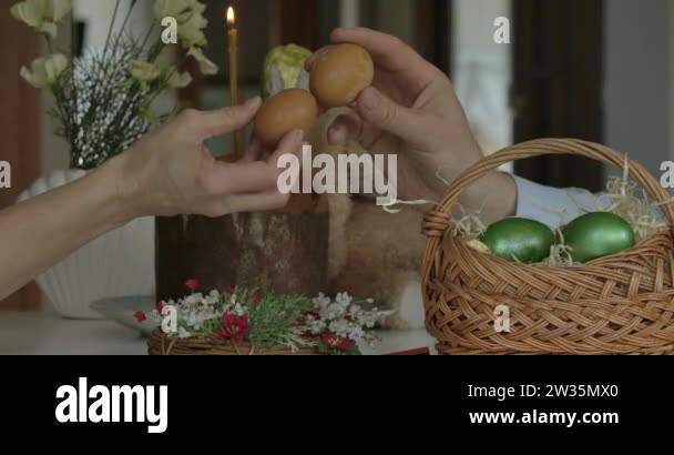 Male and female hands knocking eggs on Easter. Close-up side view of ...