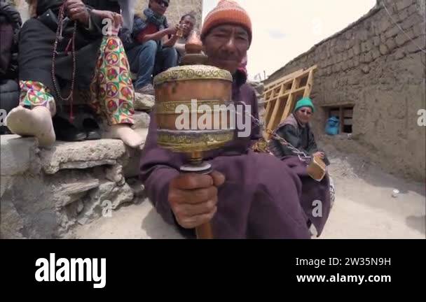 Unidentified ladakhi senior man spinning traditional buddhist praying ...