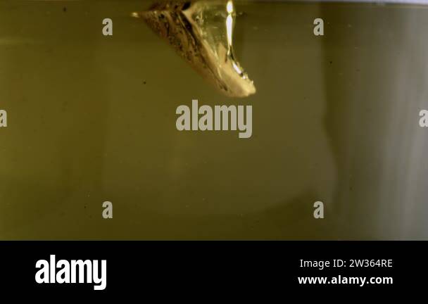 Dramatic shot of French fries falling in oil at ultra slow motion with ...