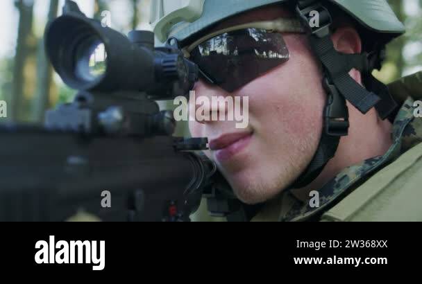 Close up of solider using assault rifle while protecting military base ...