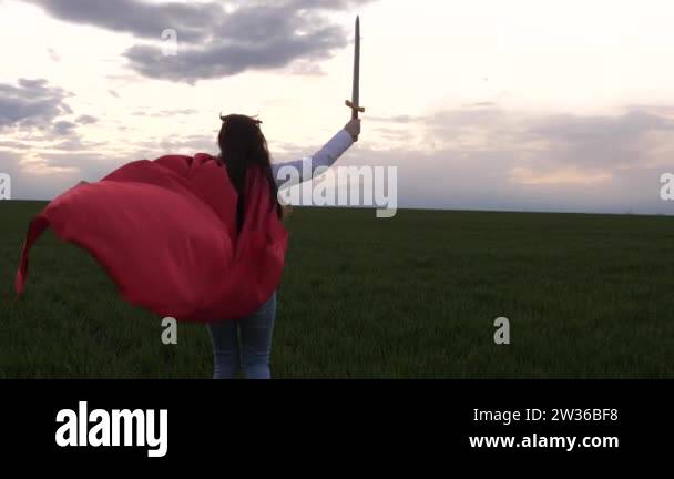 children fight with a toy sword. free girl in a red cloak runs with ...