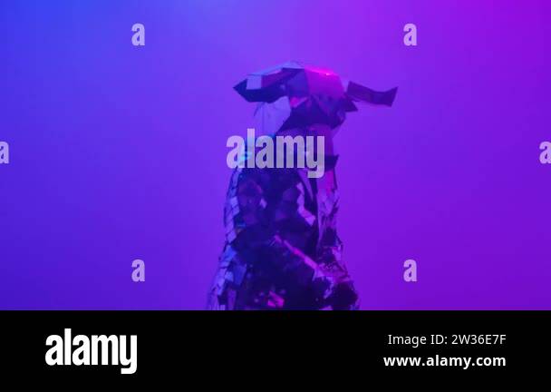 Shiny silver bull in costume made of mirrors dancing on neon blue pink ...