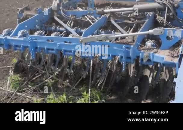 Disking the soil. Short disc harrow. Powerful multi-purpose tractor in ...