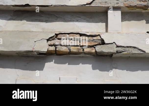 Damaged and peeled plaster on the brick house exterior facade wall ...